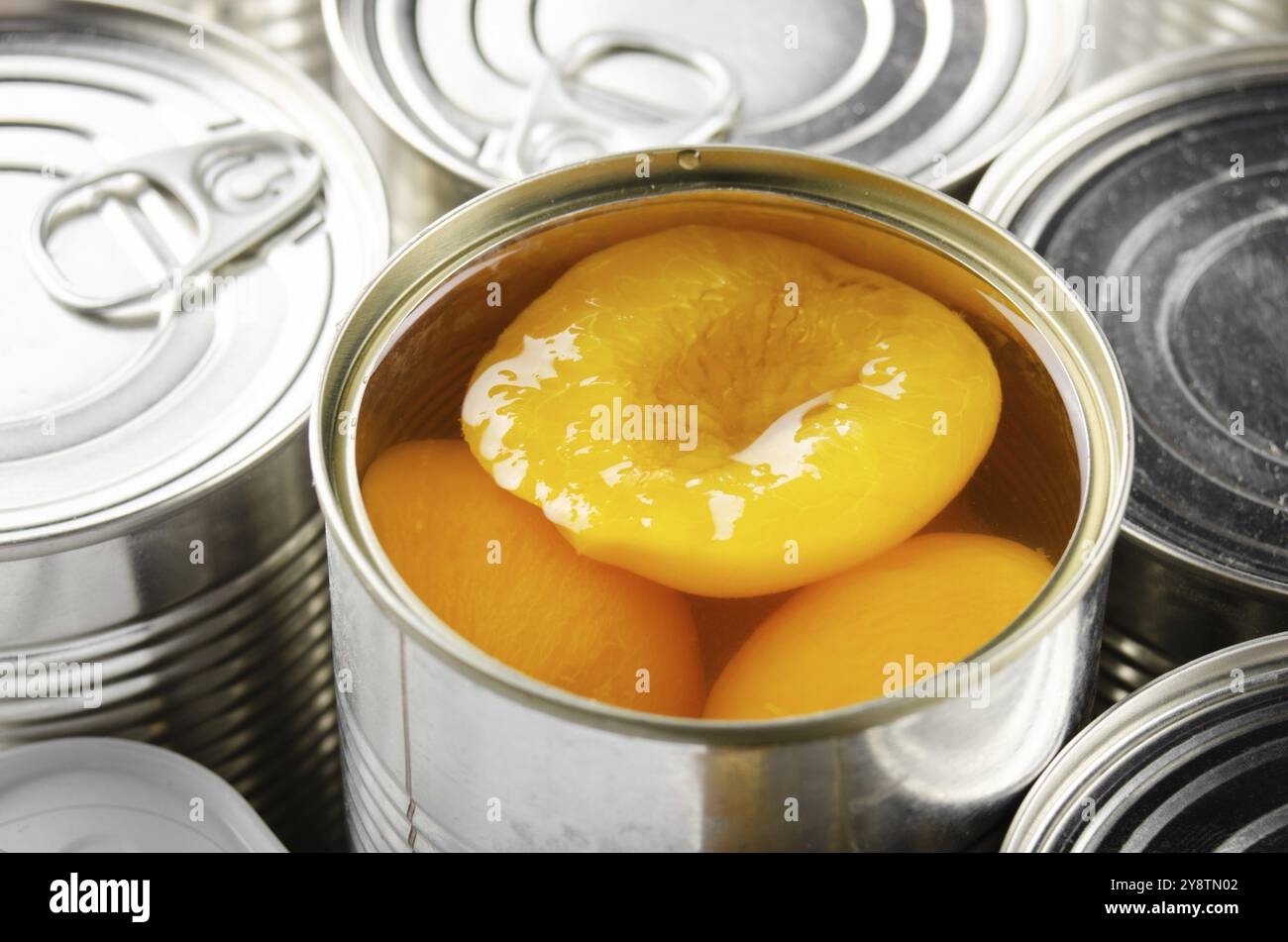 Canned peaches in just opened tin can. Non-perishable food Stock Photo ...