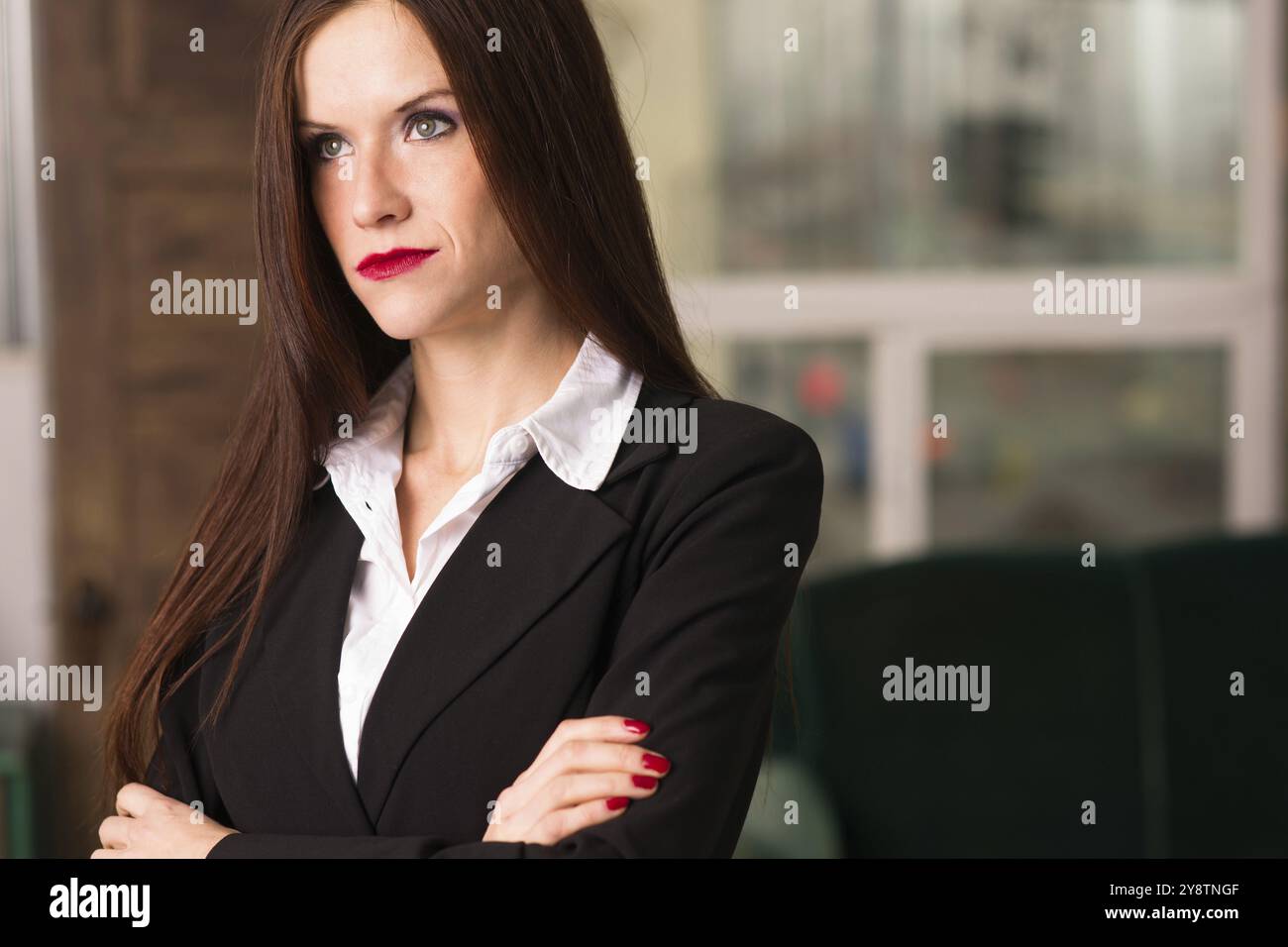 Beautiful young adult woman looks right at camera in the office Stock Photo - Alamy