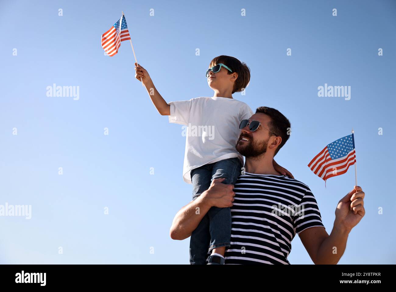 Happy father and son with flags of USA outdoors. Space for text Stock ...