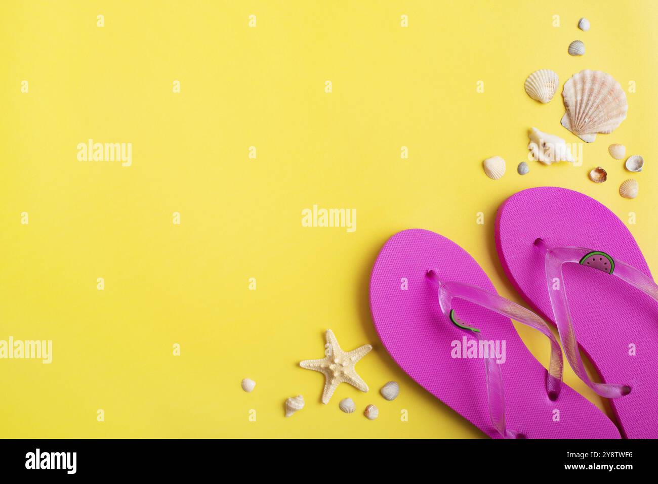 Flip flops with shells and starfishes on yellow background vacation ...