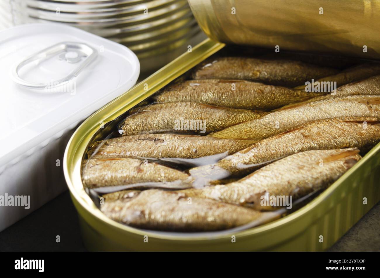 Canned smoked fish sprats in just opened tin can. Non-perishable food ...