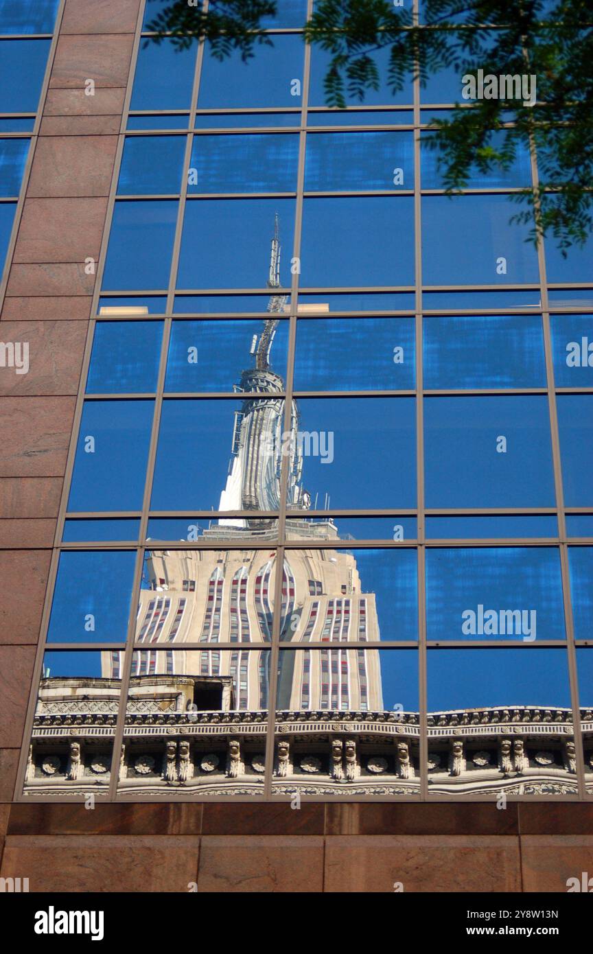 New York City’s famed Empire State Building is reflected in the glass ...