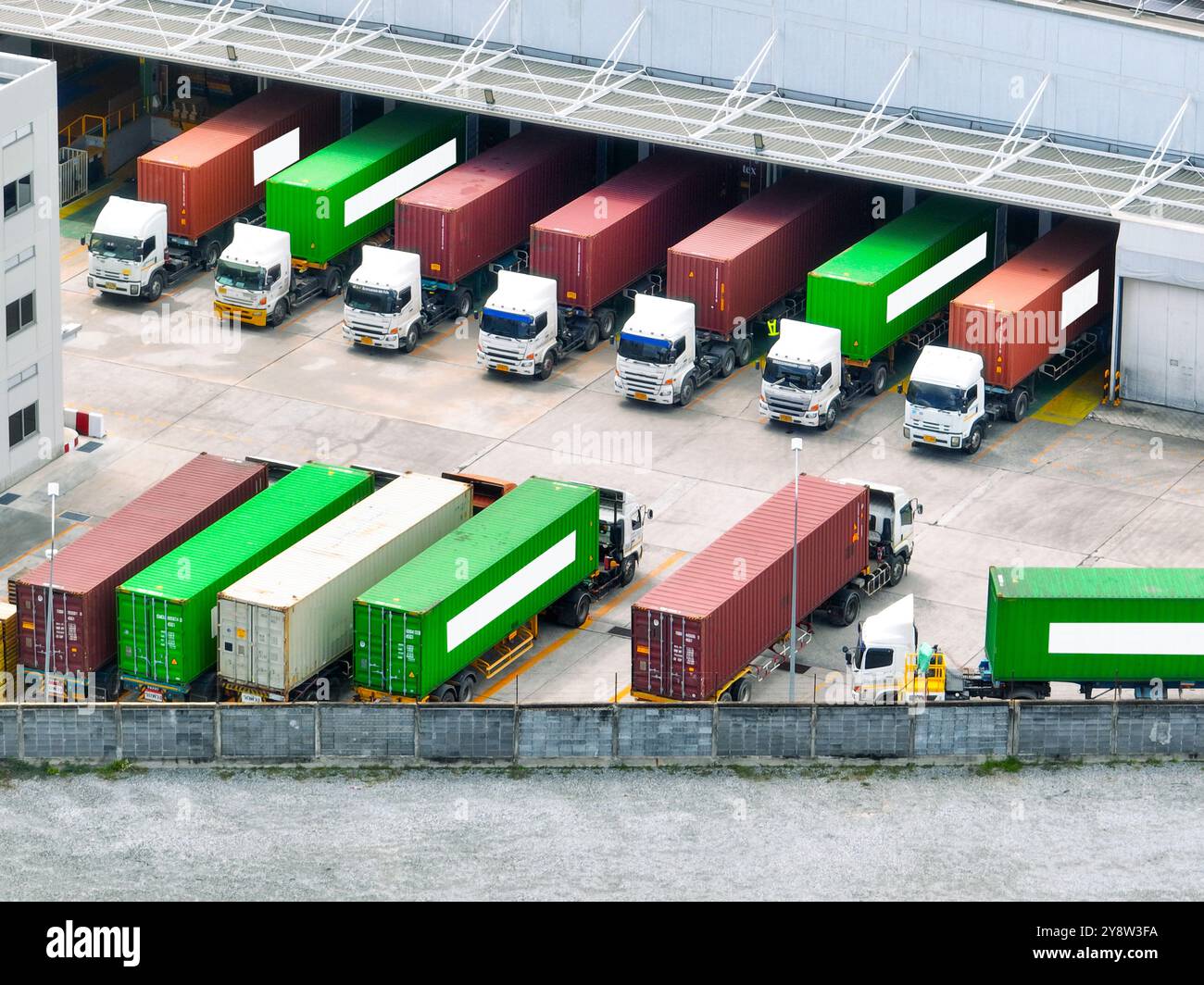 Freight trucks at warehouse loading dock. Industry logistics and distribution center. Logistics ...