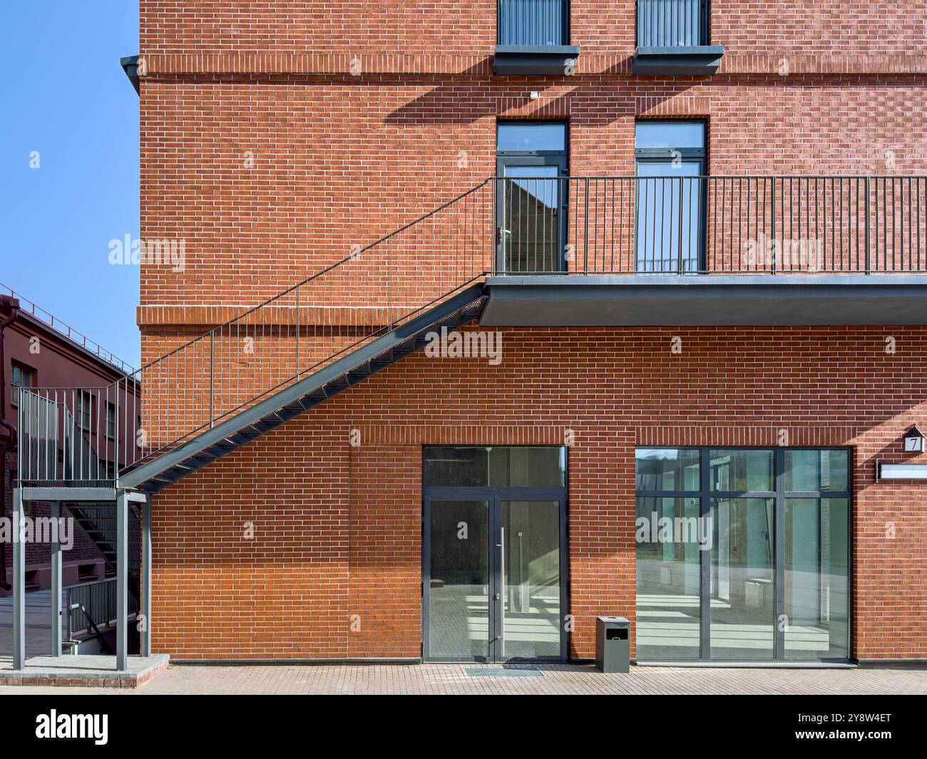 red brick wall of renovated building. outdoor metal staircase on the ...