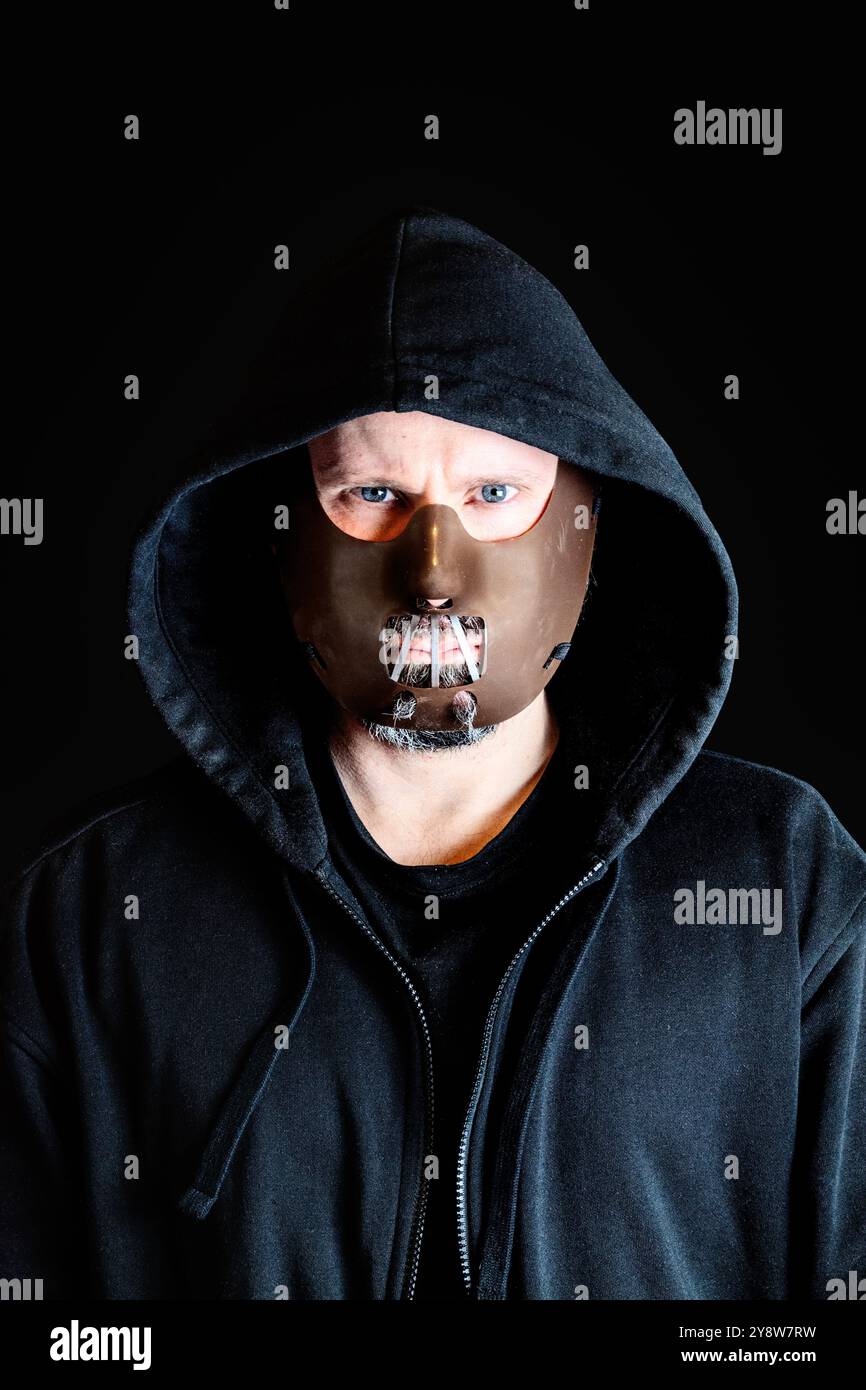 Man in a black hoodie wearing a bite mask Stock Photo - Alamy