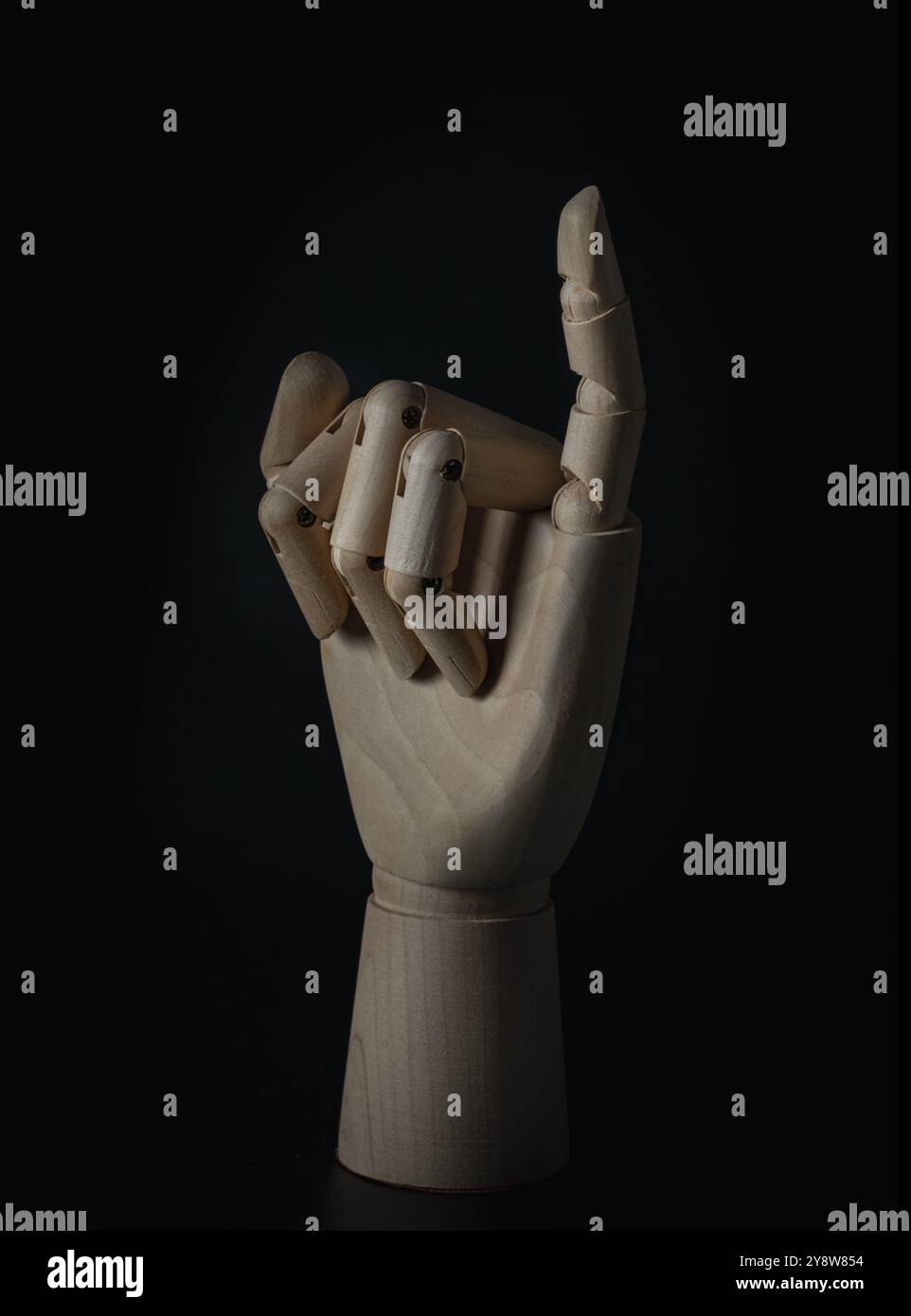 Wooden hand of mannequins showing little finger up sign on dark ...