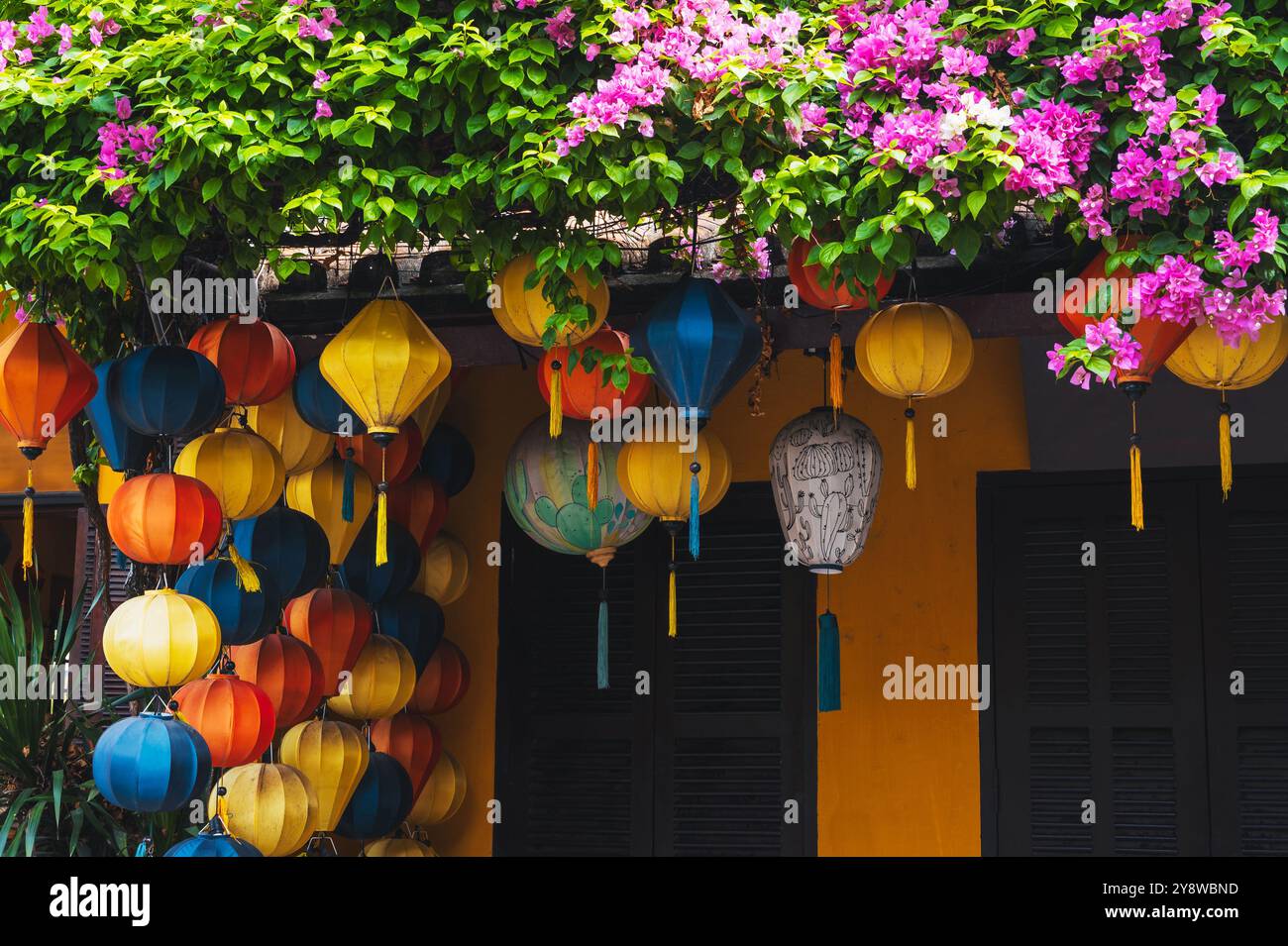 Colorful silk Chinese lanterns decorate the wall of a house for a ...