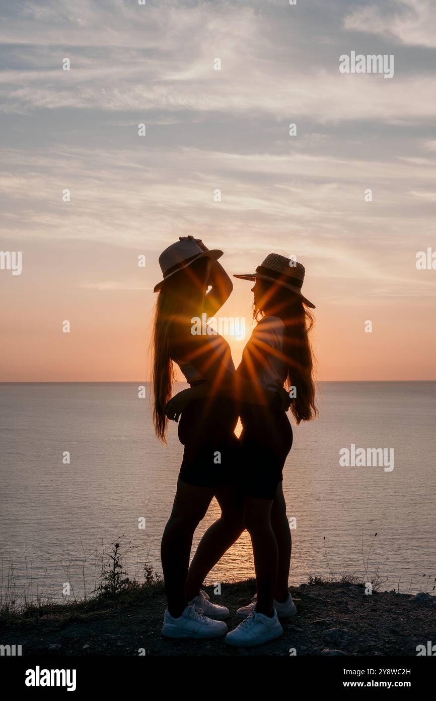 Silhouettes of Two Women in Hats at Sunset Stock Photo - Alamy