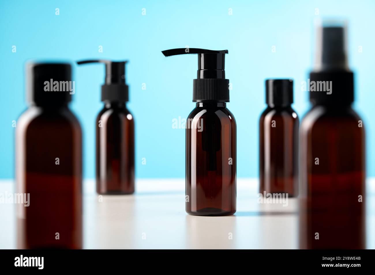 Collection of amber glass bottles with pumps and spray tops on a light ...