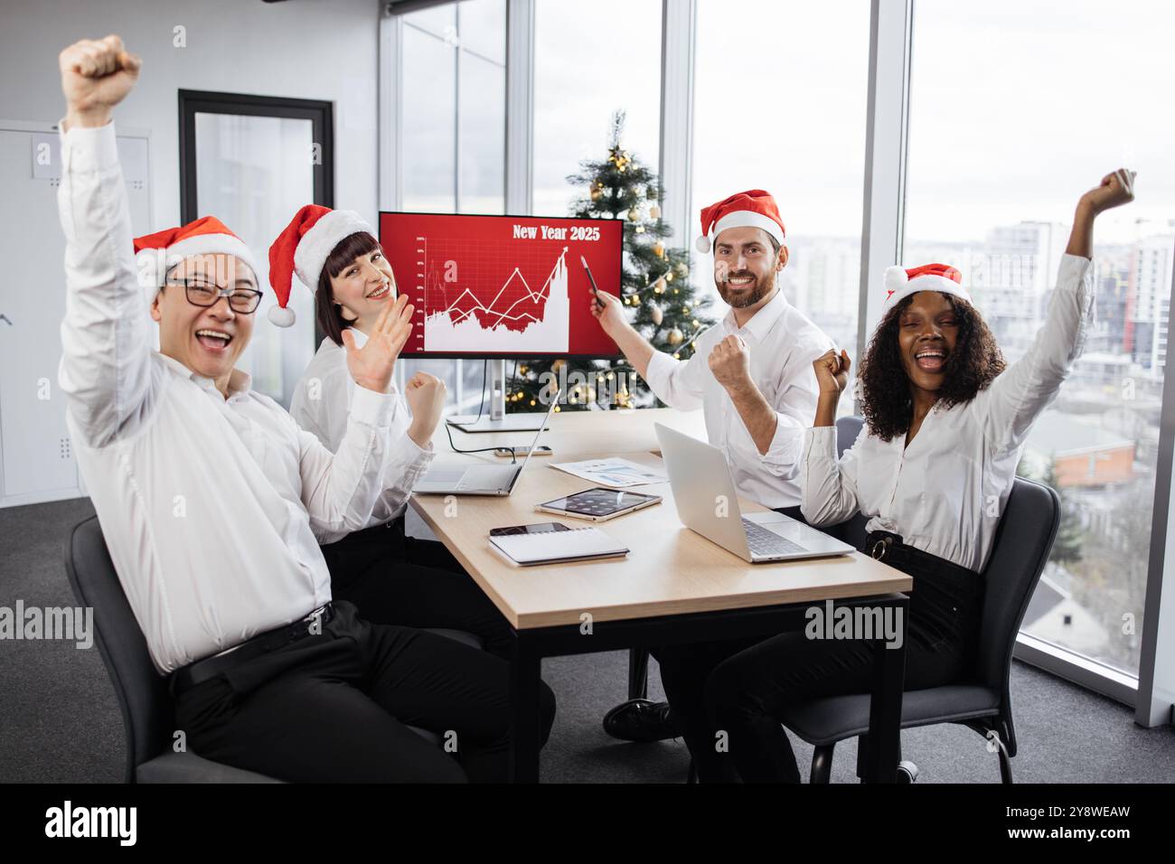 Team of business people in Santa hats raising hands Stock Photo - Alamy