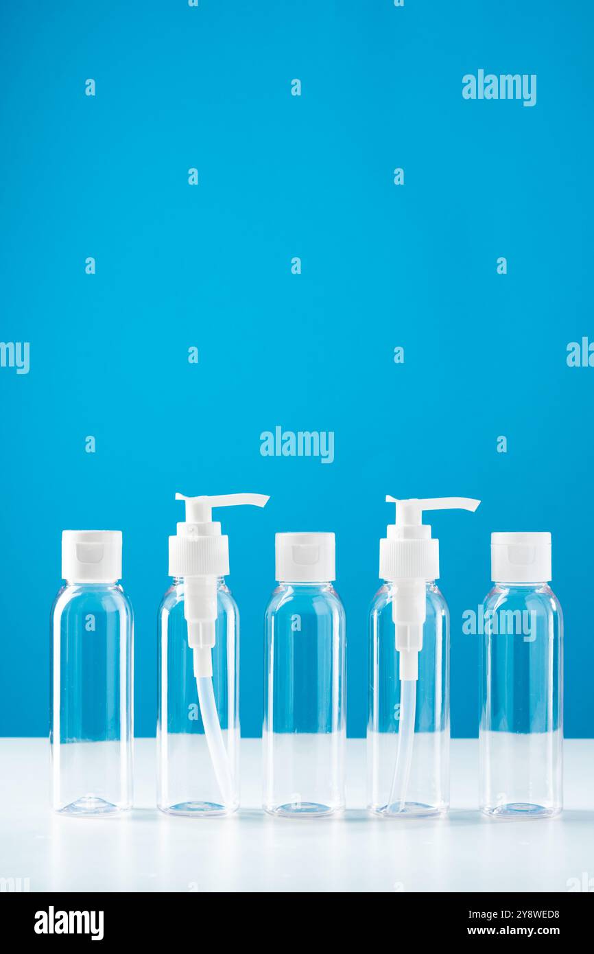 Clear plastic bottles with pumps arranged on a table against a bright ...