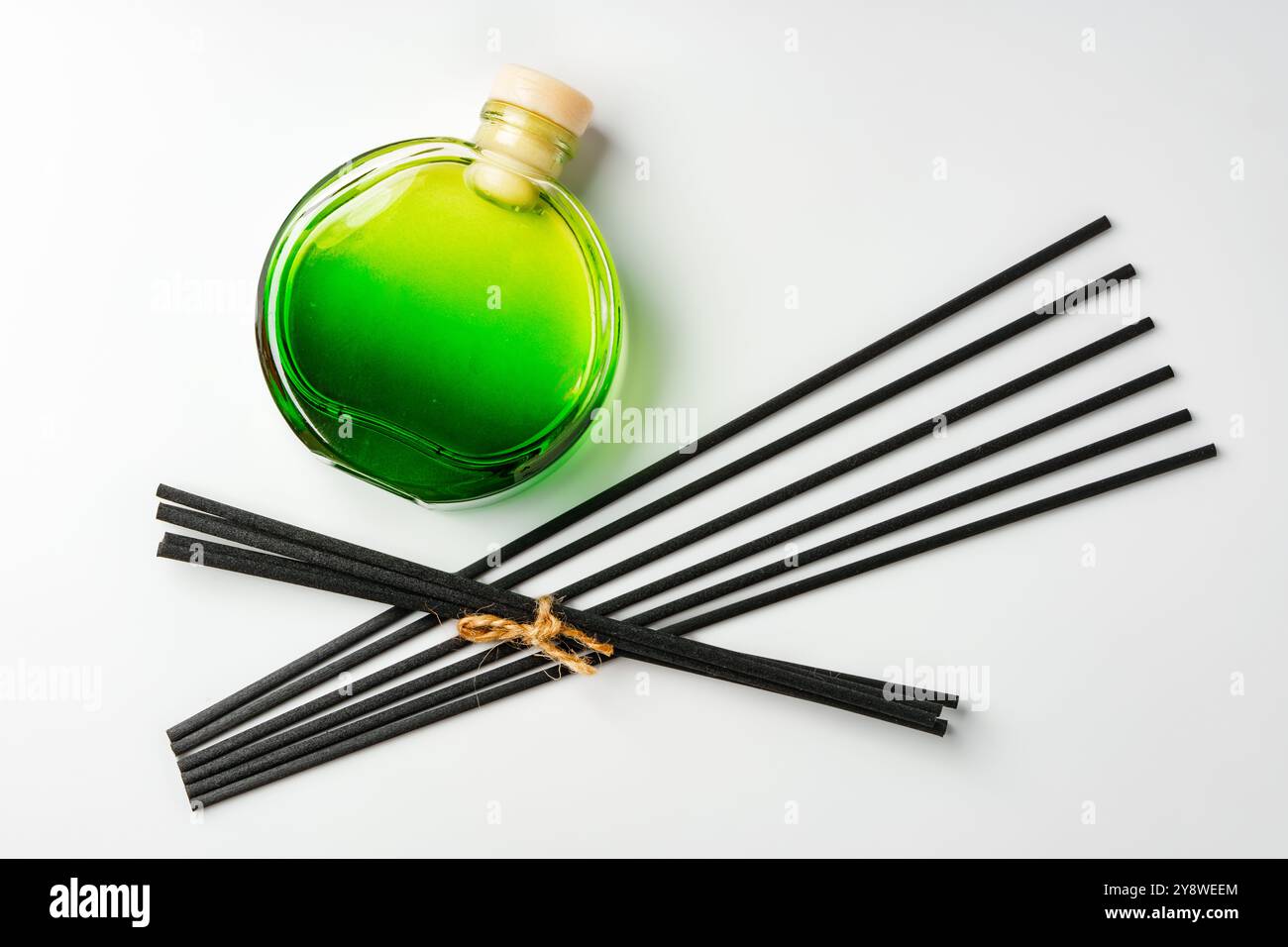 A minimalist display of essential oil and black diffuser sticks on a ...