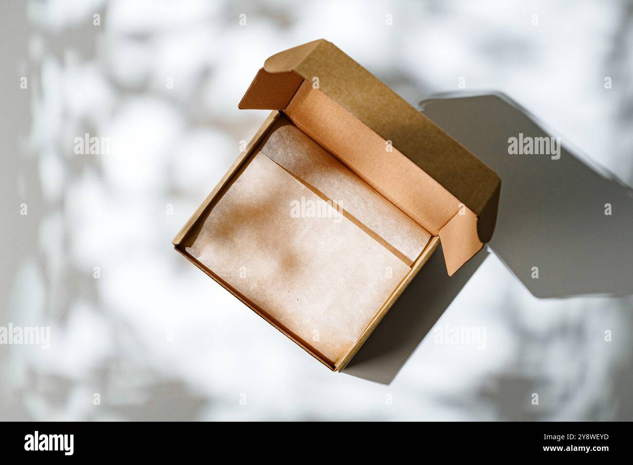 A small, empty cardboard box with unwrapped parchment resting inside on ...