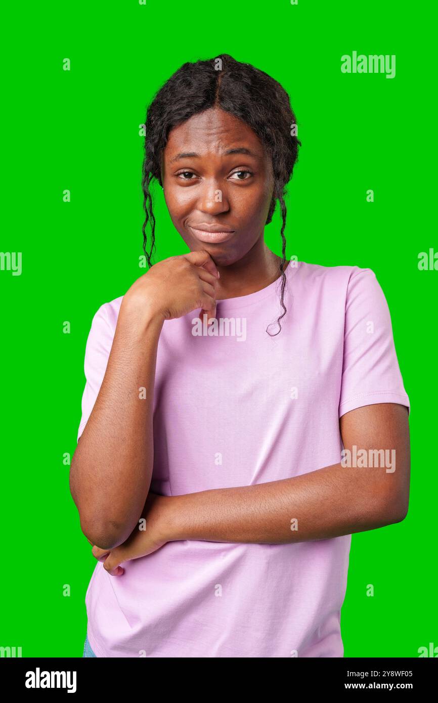 Thoughtful woman pondering in front of a bright green background during ...