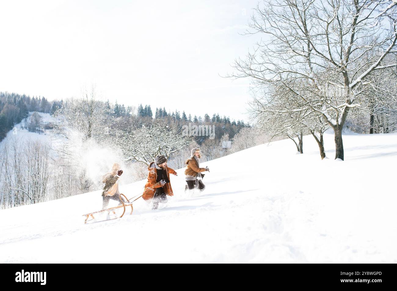 Group of friends pulling sleds behind them, going to sleddingin in ...