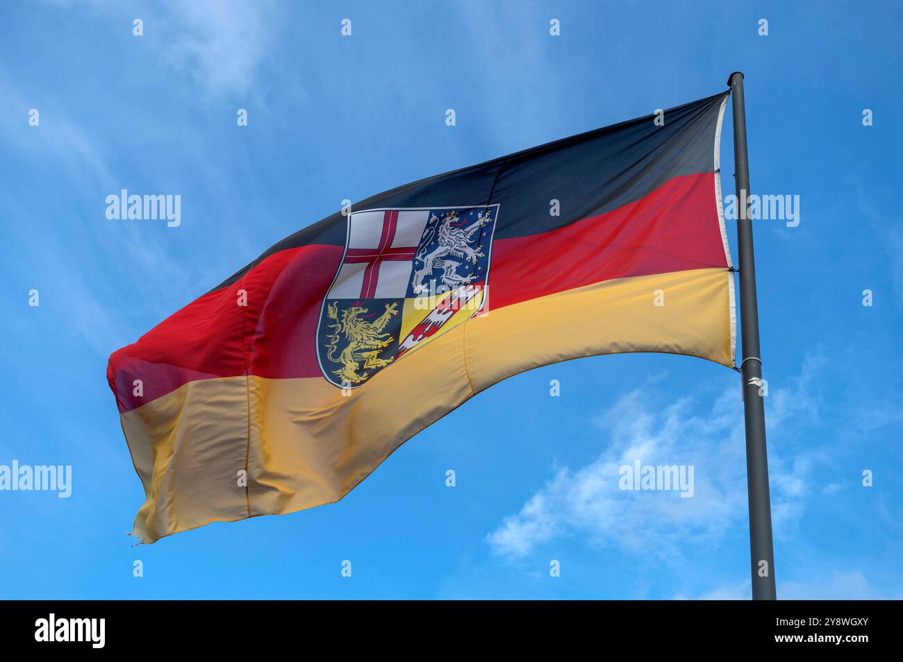 Flag of Saarland flying in the wind with a blue sky background ...