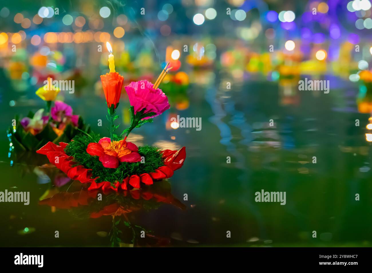 Krathong for Loy Krathong Festival in Thailand floating on dirty river ...