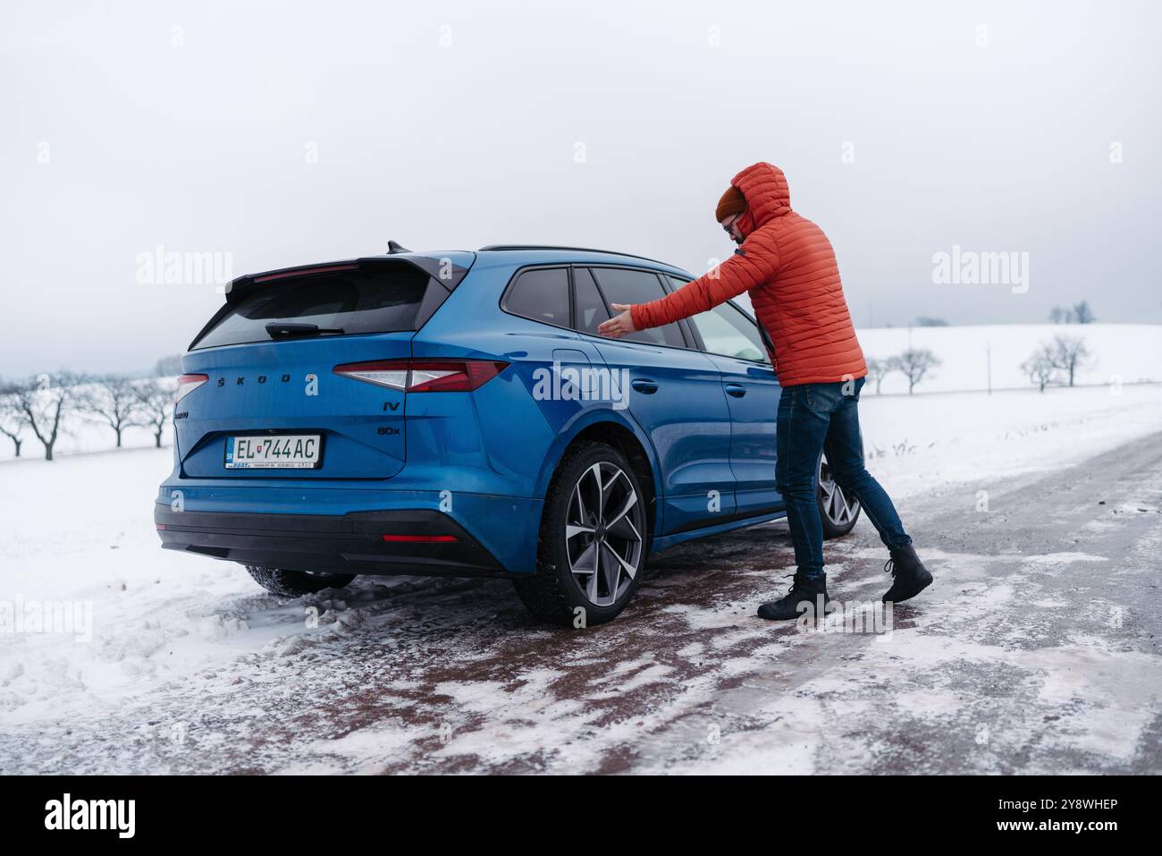 Angry man standing by electric car, battery run out of power before ...