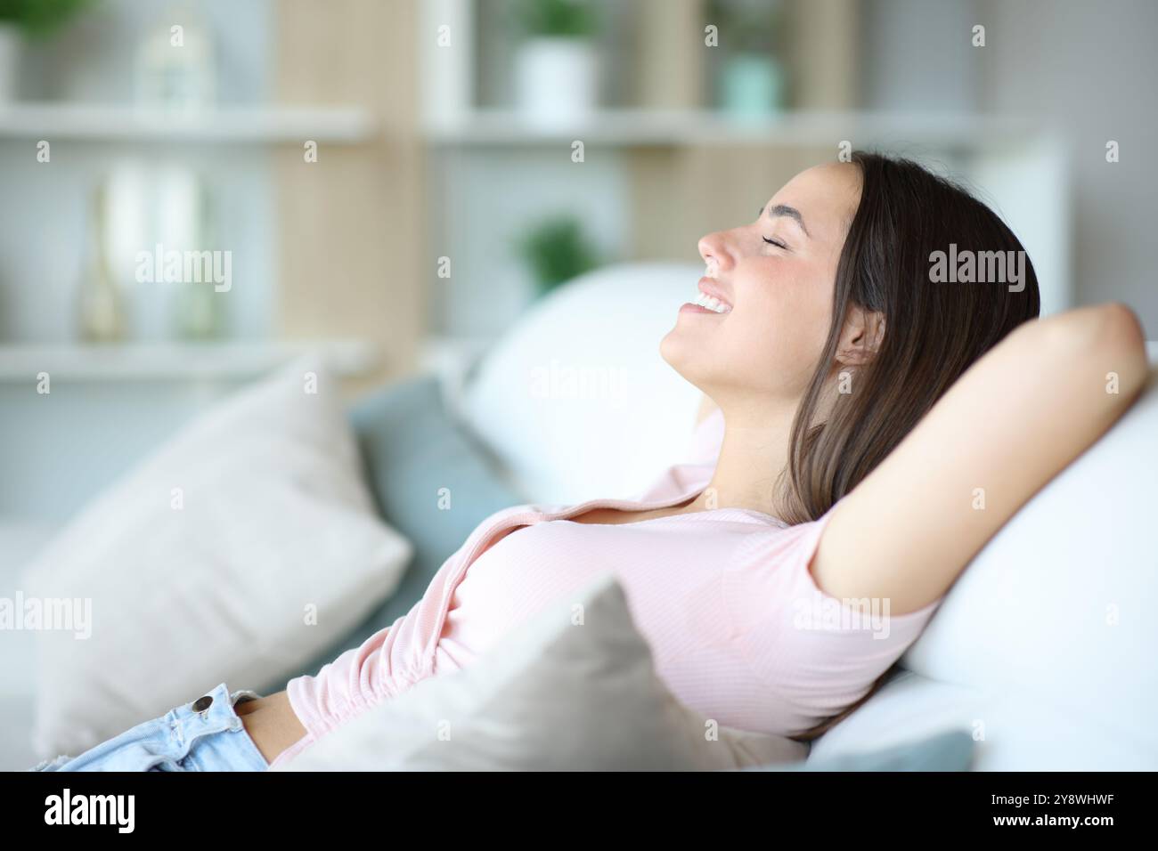 Side view portrait of a happy woman relaxing sitting in a comfortable ...