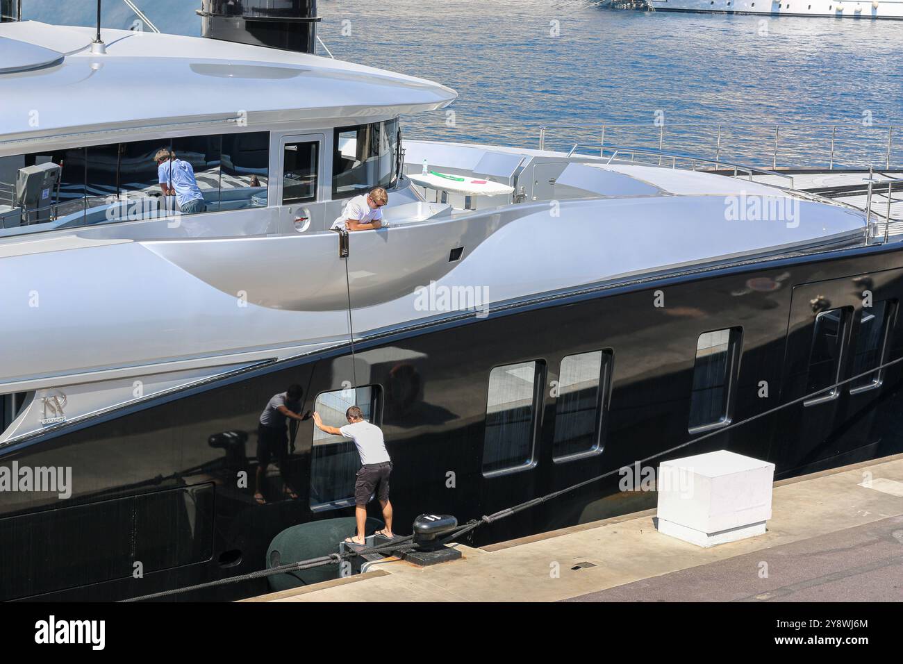 Crew members ensuring cleaning, maintenance of large windows of a super ...