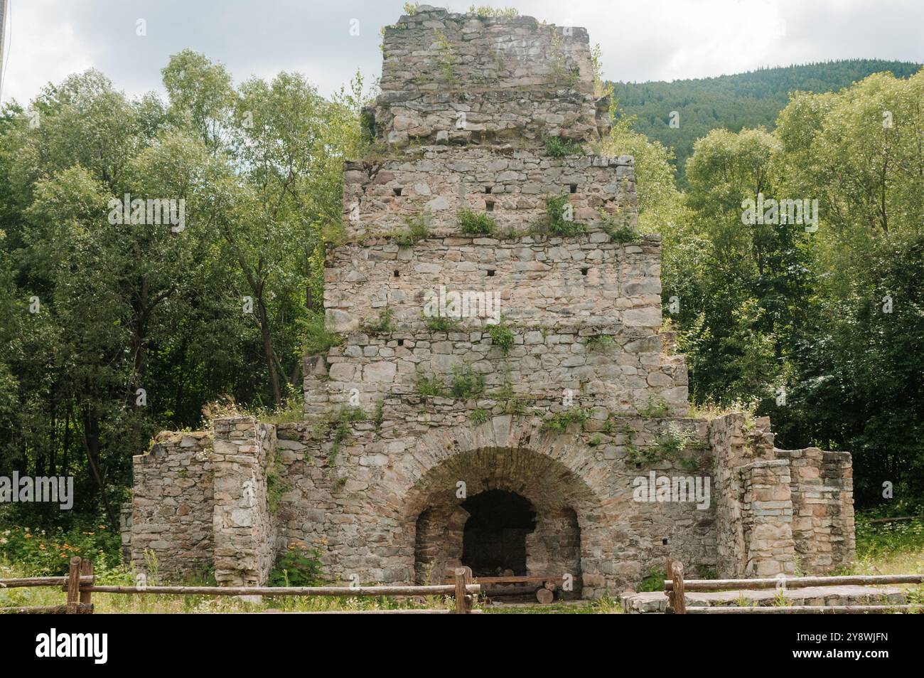 Ancient Stone Ruins Surrounded by Lush Greenery and Majestic Mountains Stock Photo - Alamy
