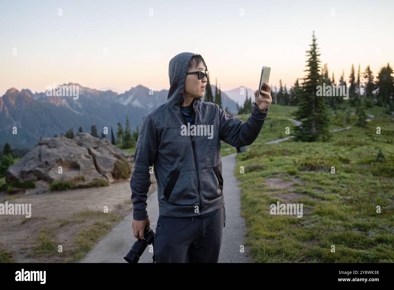 Man taking selfie photos in Paradise at sunset. Mount Rainier National ...