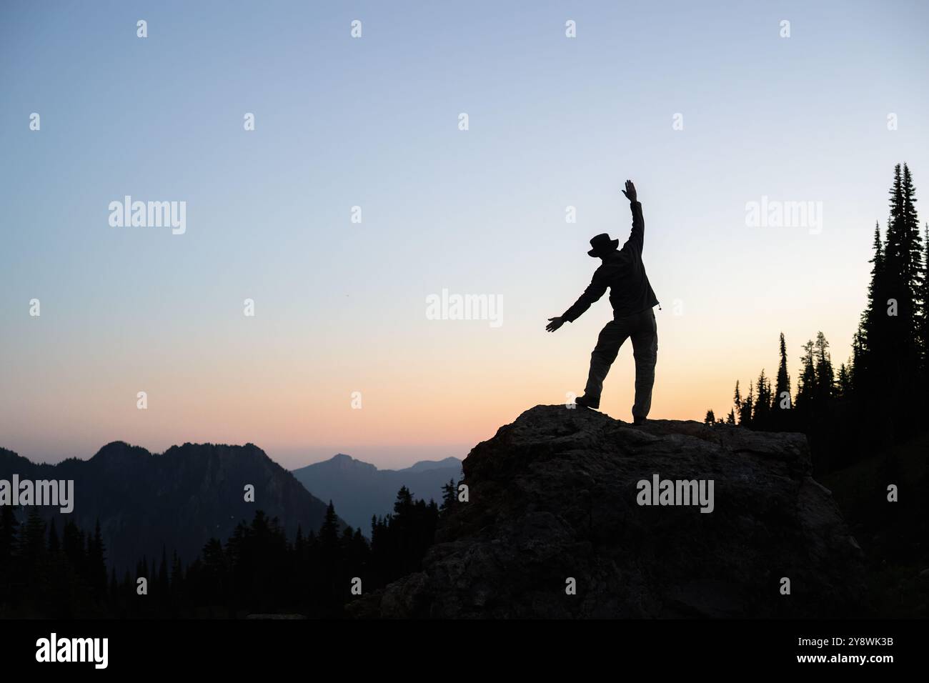 Man in silhouette raising arms at sunset. Paradise. Mount Rainier ...