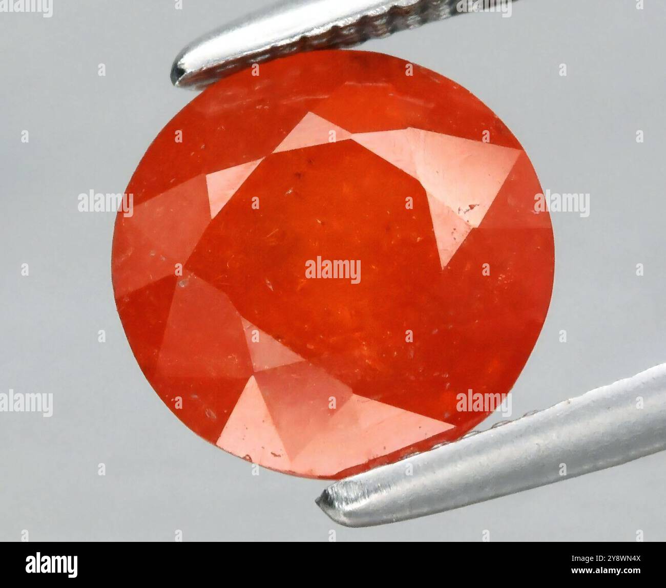 Radiant Orange Gemstone Displayed in Precision Claws Stock Photo - Alamy