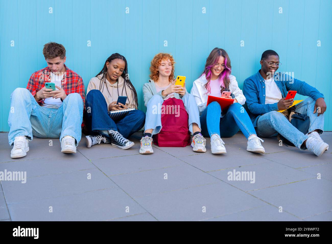 Diverse Young People Sitting Outdoors Using Smartphones Stock Photo Alamy