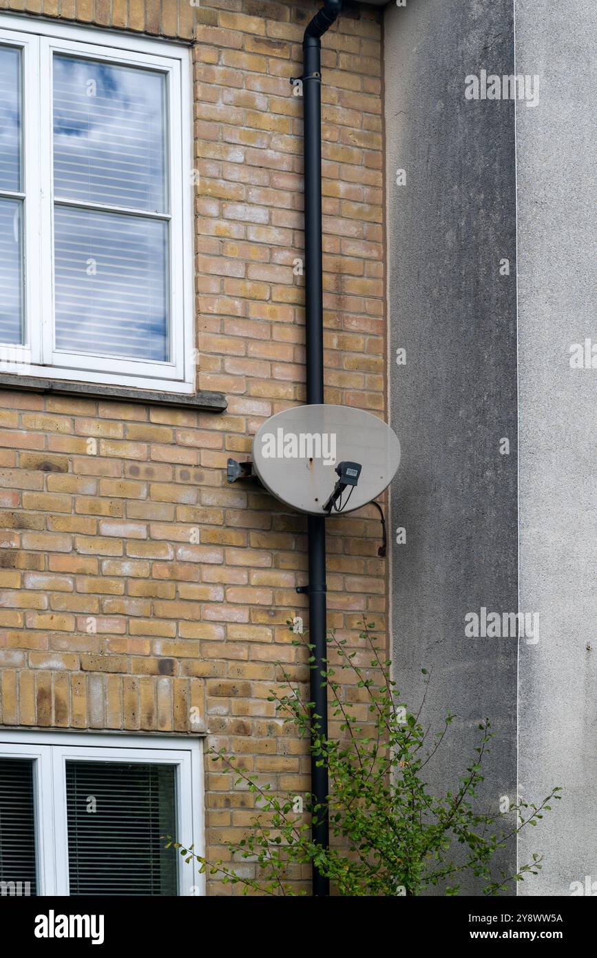 Old fashioned Sky satellite dish mounted outside of an apartment block ...