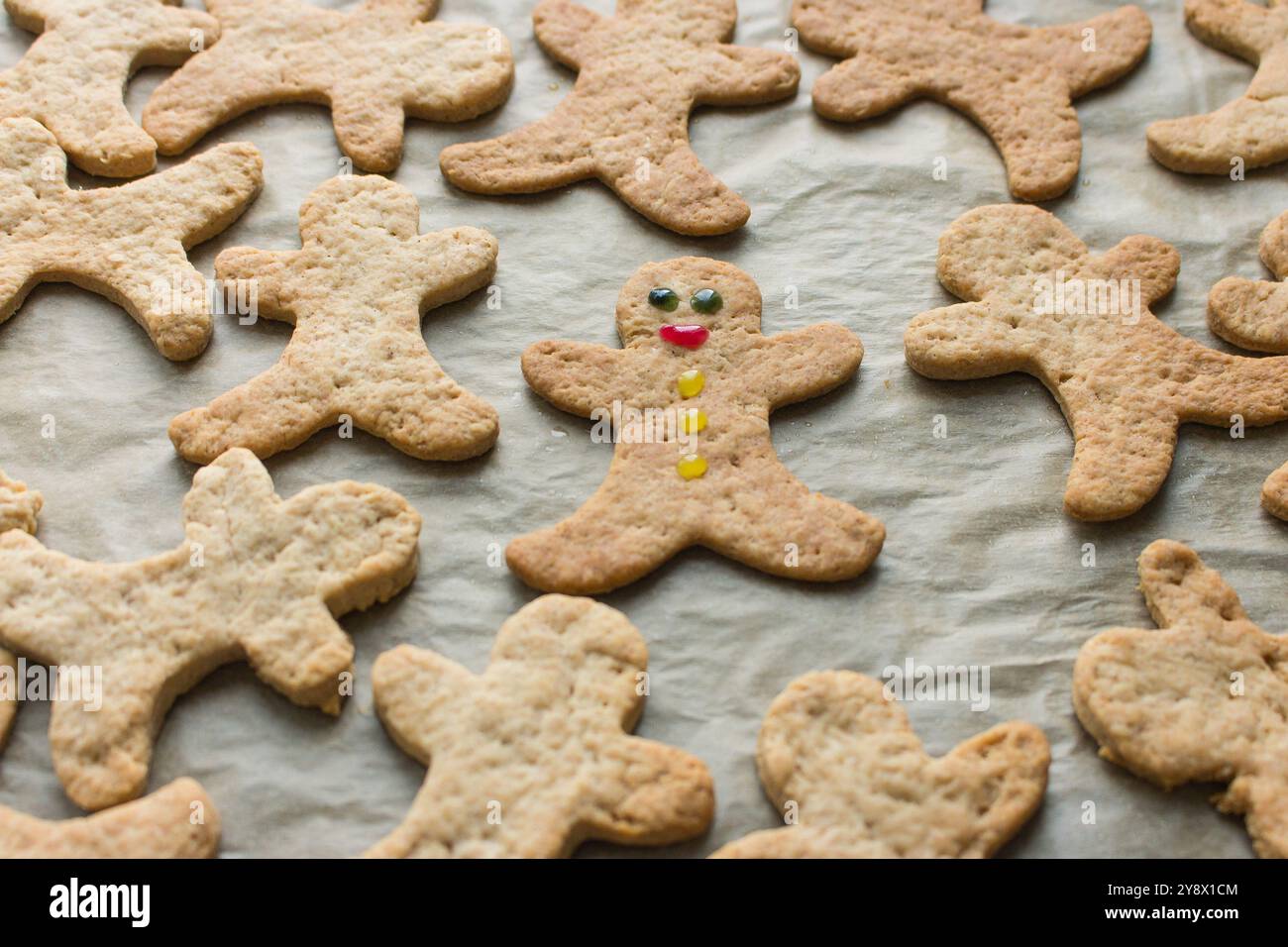 Gingerbread man cookies on baking tray. The only one decorated cookie ...
