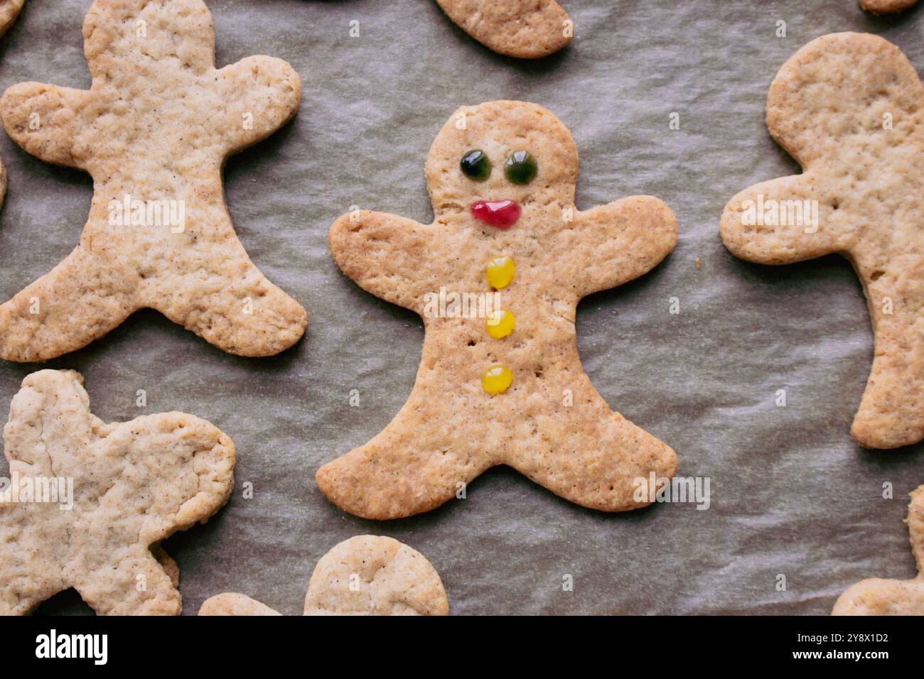 Gingerbread man cookies on baking tray. The only one decorated cookie ...
