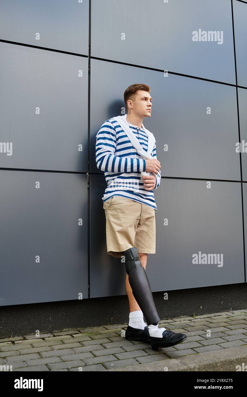 A handsome young man stands confidently at a contemporary building ...