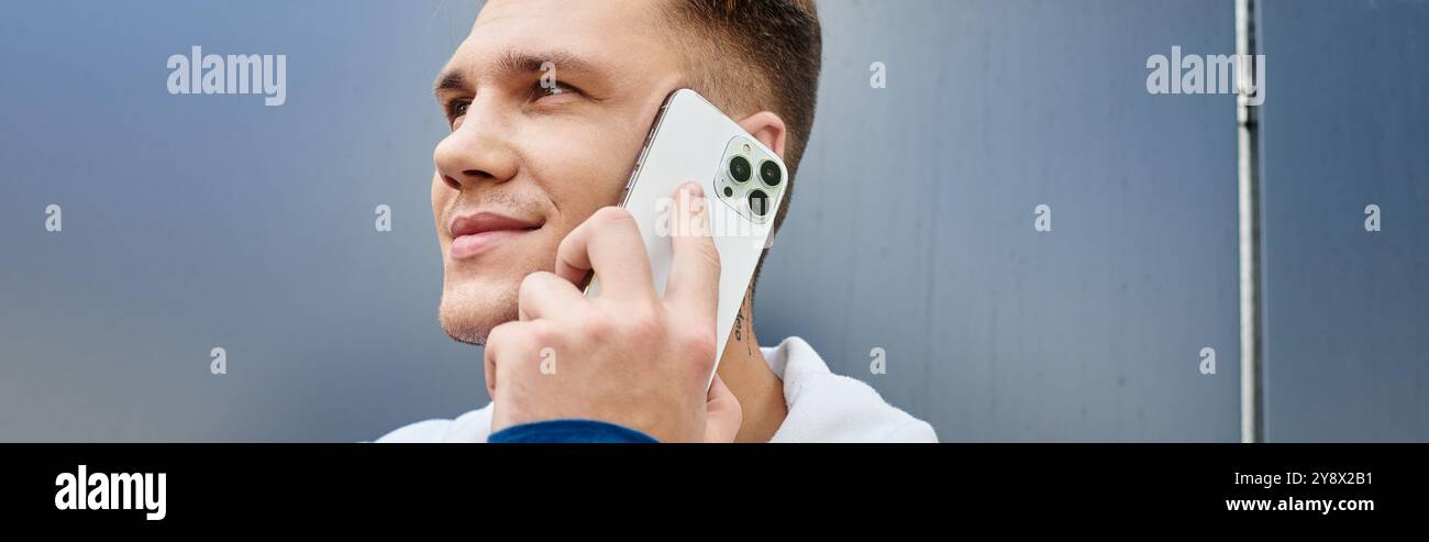 A young man engages in a phone conversation, proudly displaying his ...