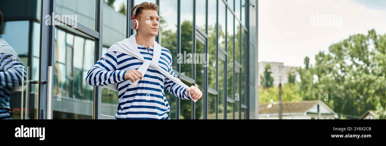 A determined young man jogs along a sleek building, showcasing strength ...