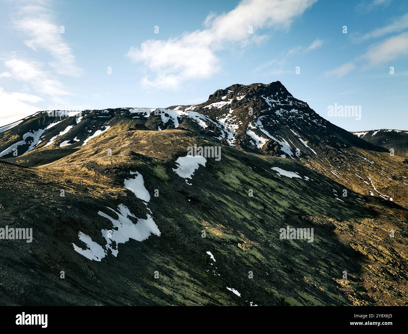 Mountain with dry grass on slopes covered with snow Stock Photo - Alamy