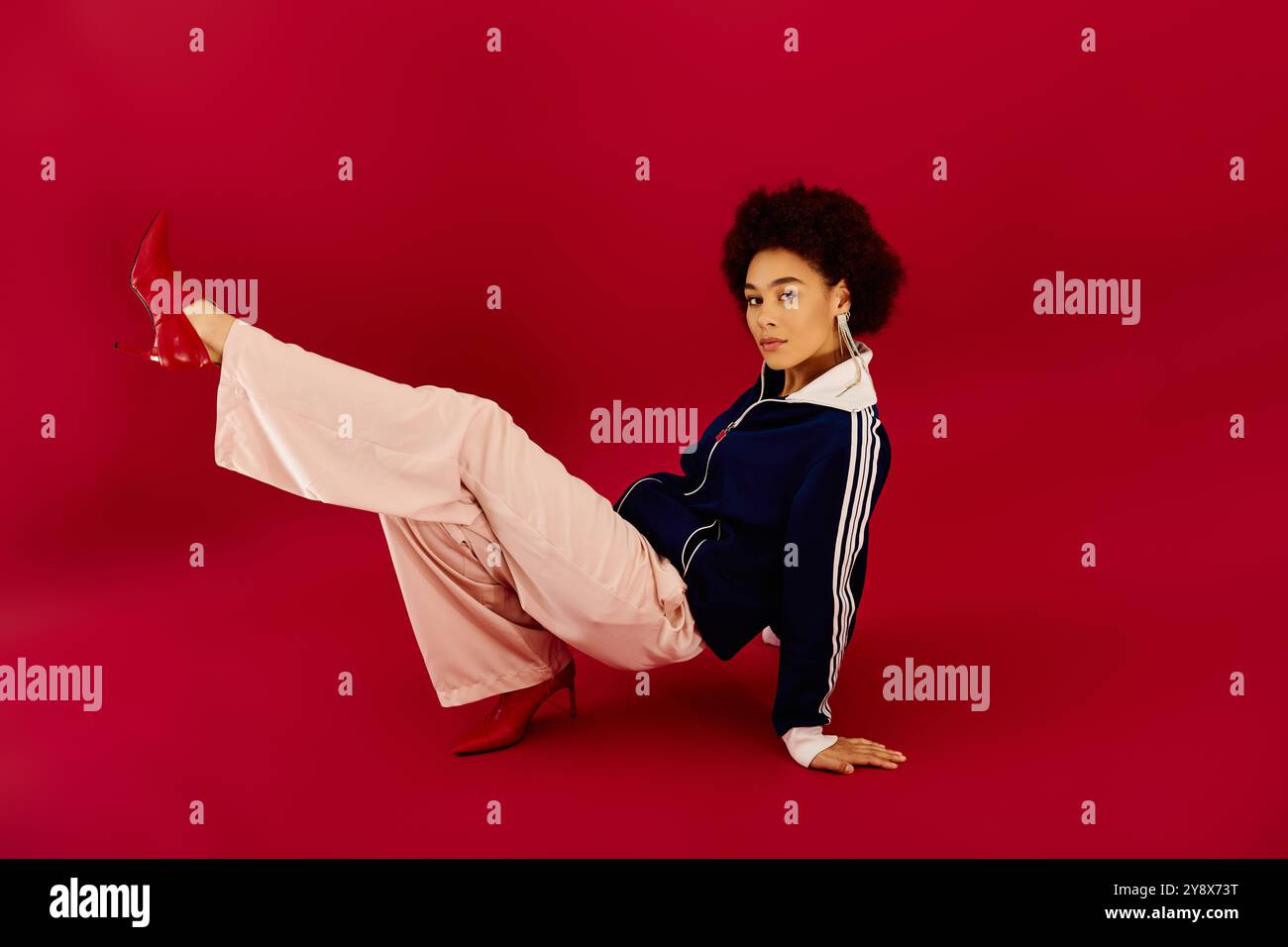 A young woman expresses emotion while balancing stylishly on one leg ...