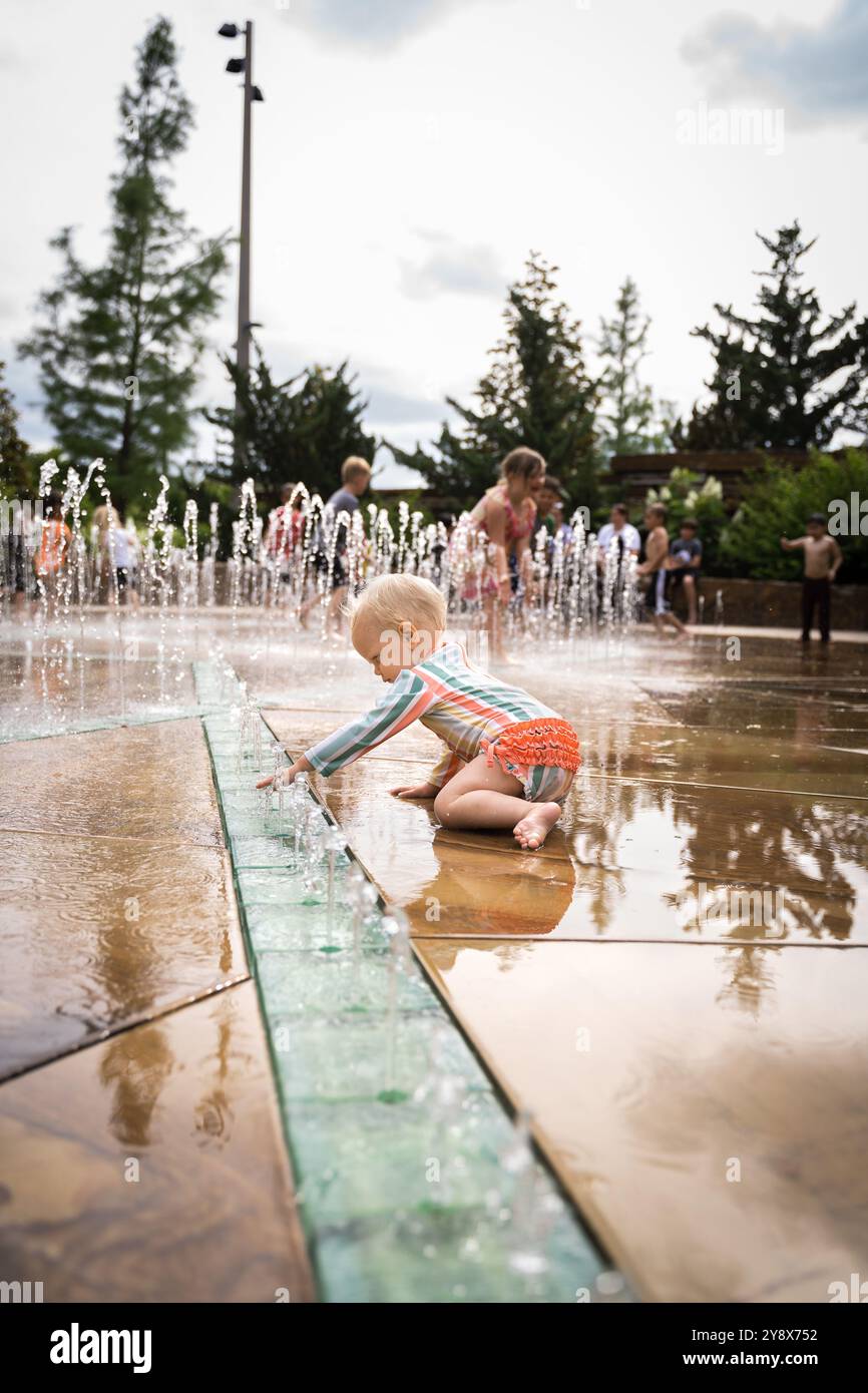 Baby Plays In Water At A Local Splash Pad Stock Photo - Alamy
