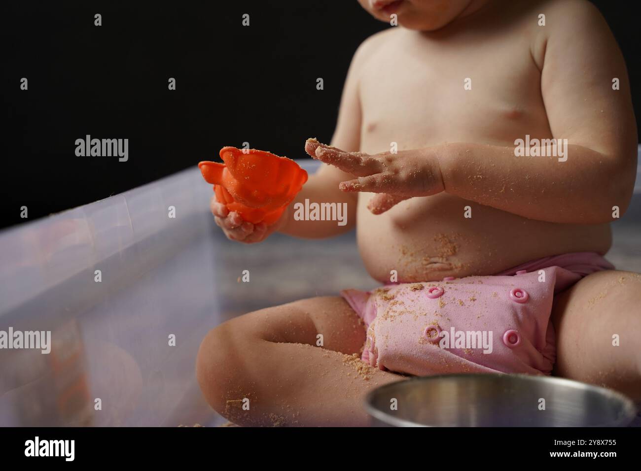 Baby Playing In A Sandy Sensory Bin Stock Photo - Alamy