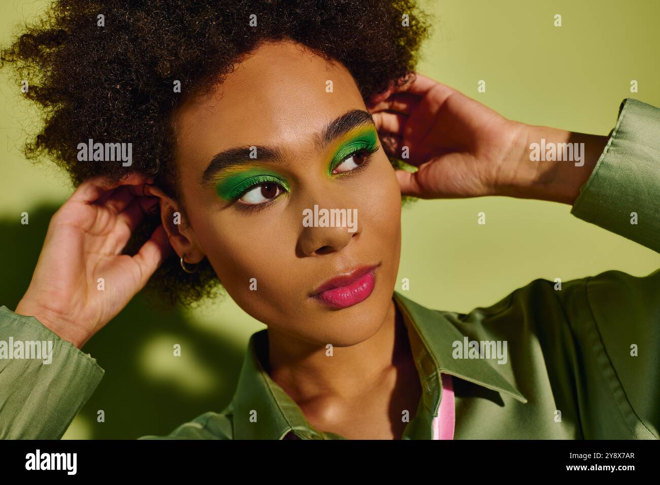 A young woman displays colorful makeup, reflecting deep emotions in a ...