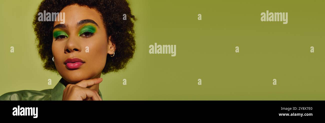 A young woman shows her emotions with bold green makeup against a ...