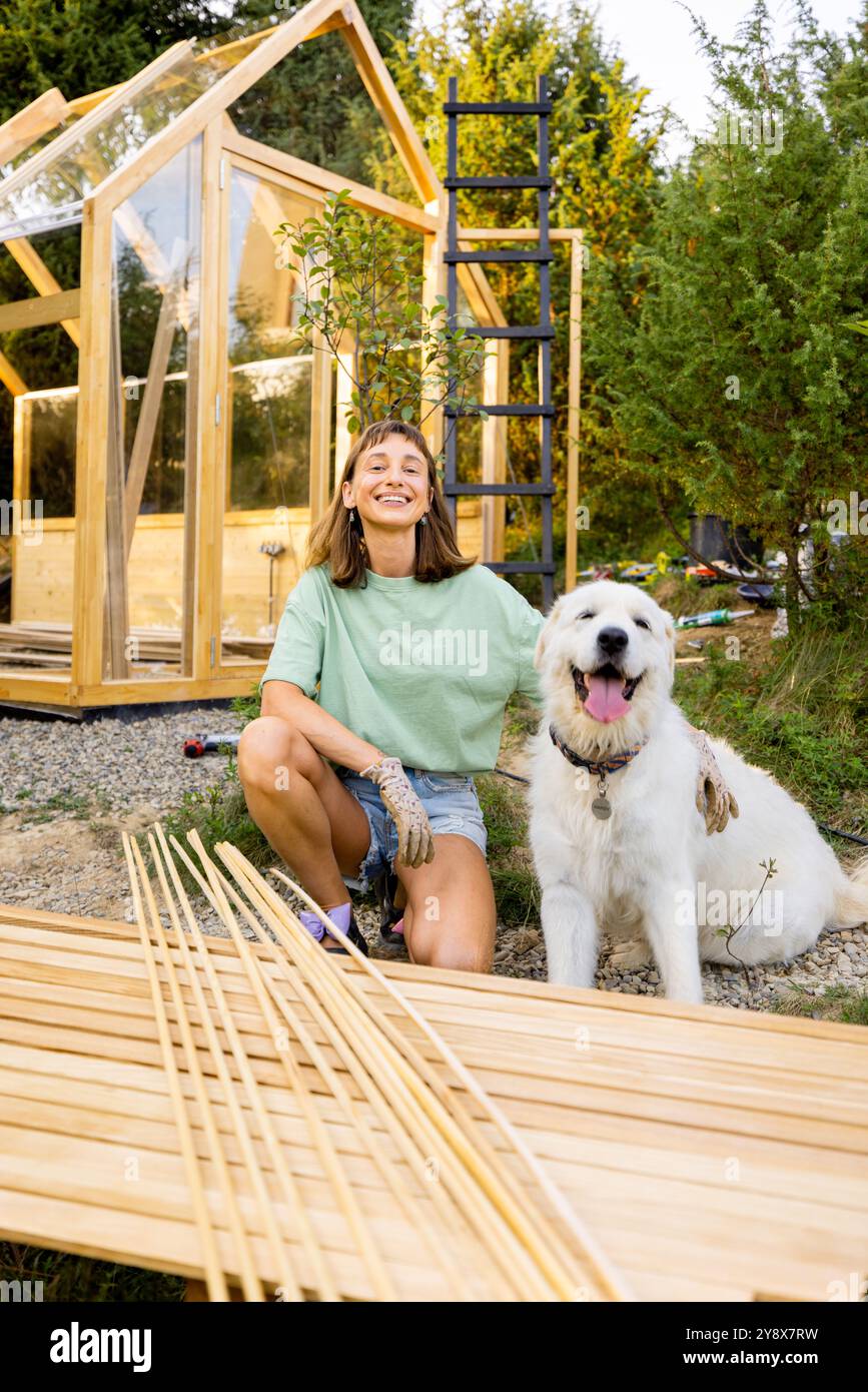 Female carpenter with her dog building wooden greenhouse Stock Photo ...