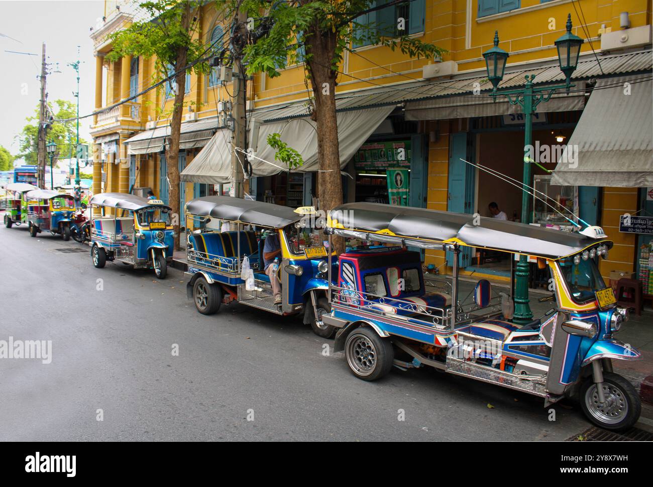 Bangkok. Tuk tuks lined up along a street in the Thai capital. This picturesque three-wheeled ...