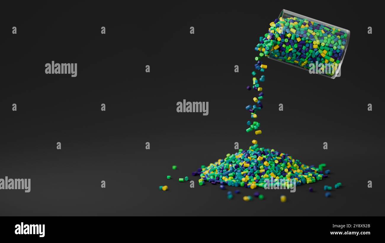 Colorful plastic polypropylene granules pouring from the glass on a ...