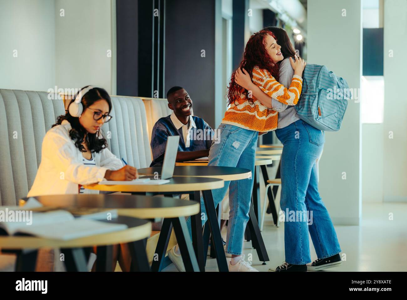 University friends happily reunite with a friendly greeting in a bright ...
