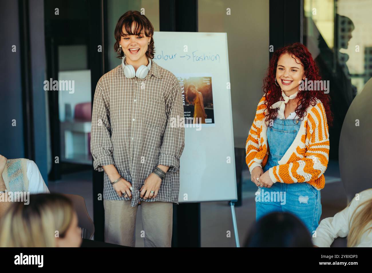 Two confident students lead a creative presentation in a classroom ...
