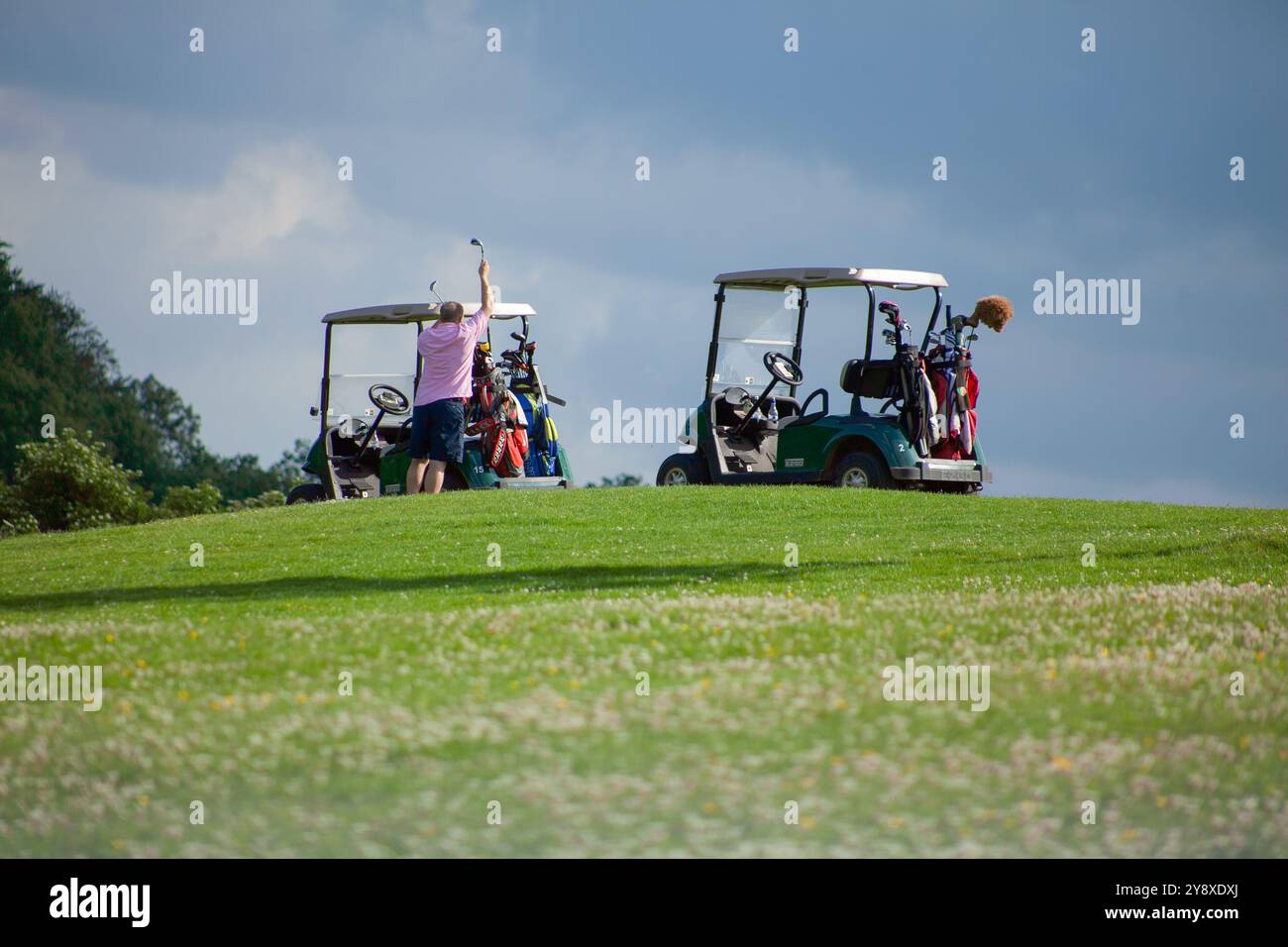 golf buggy in distance on golf course hill Stock Photo - Alamy