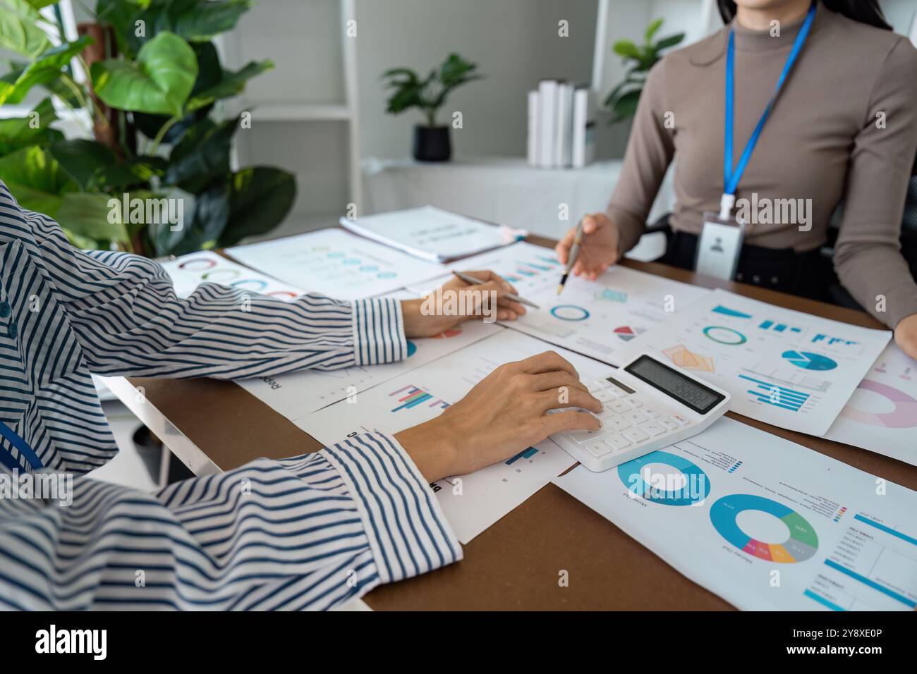 Collaborative Business Meeting with Charts and Calculator in a Modern ...