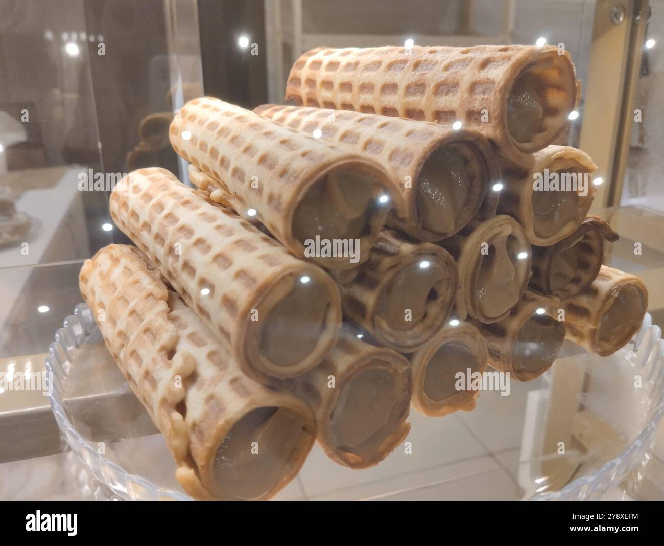 Waffle rolls with condensed milk cream lie in a pile in the window of a ...