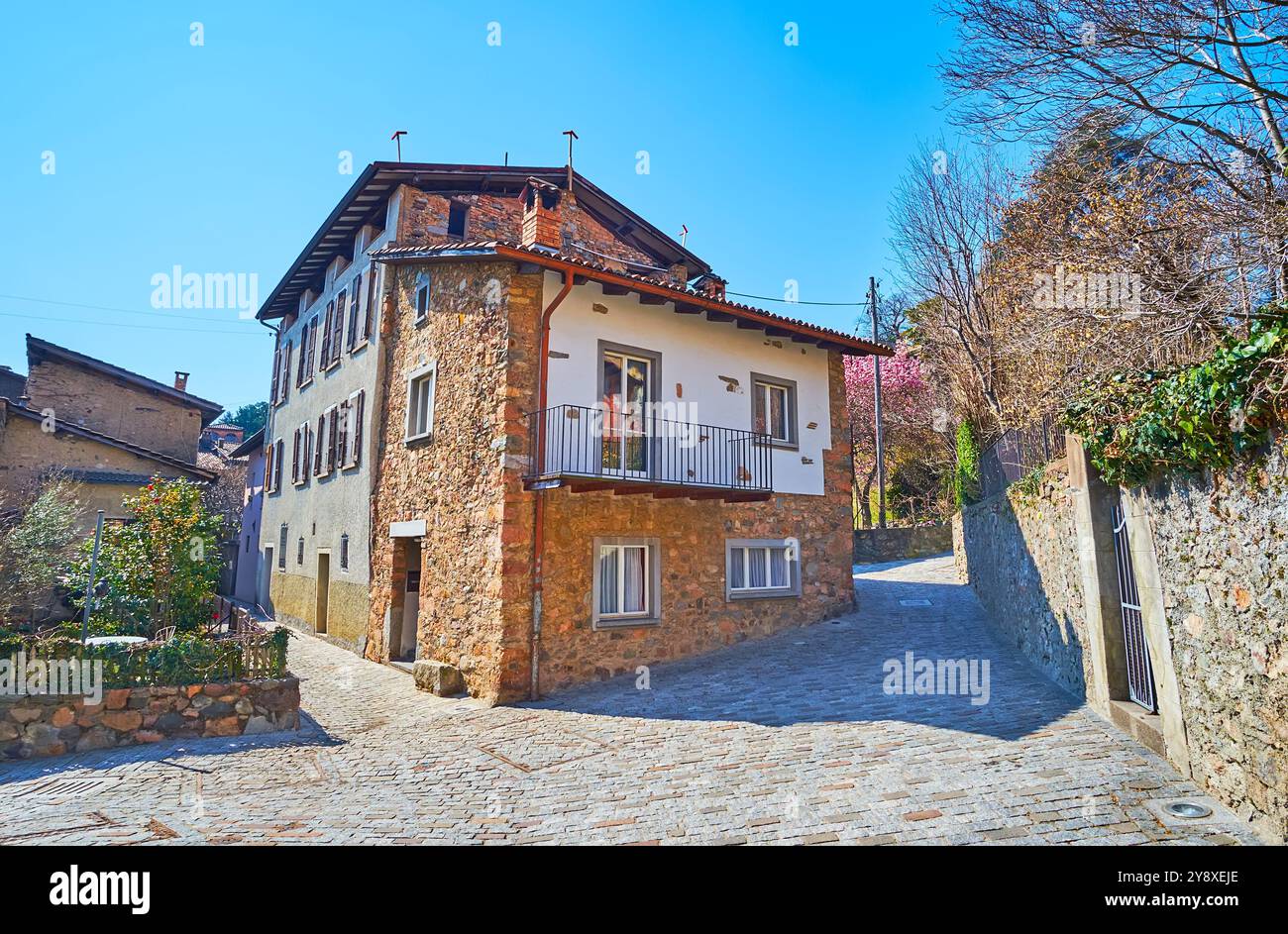 The stone living houses and lush gardens in old Carona, Ticino ...